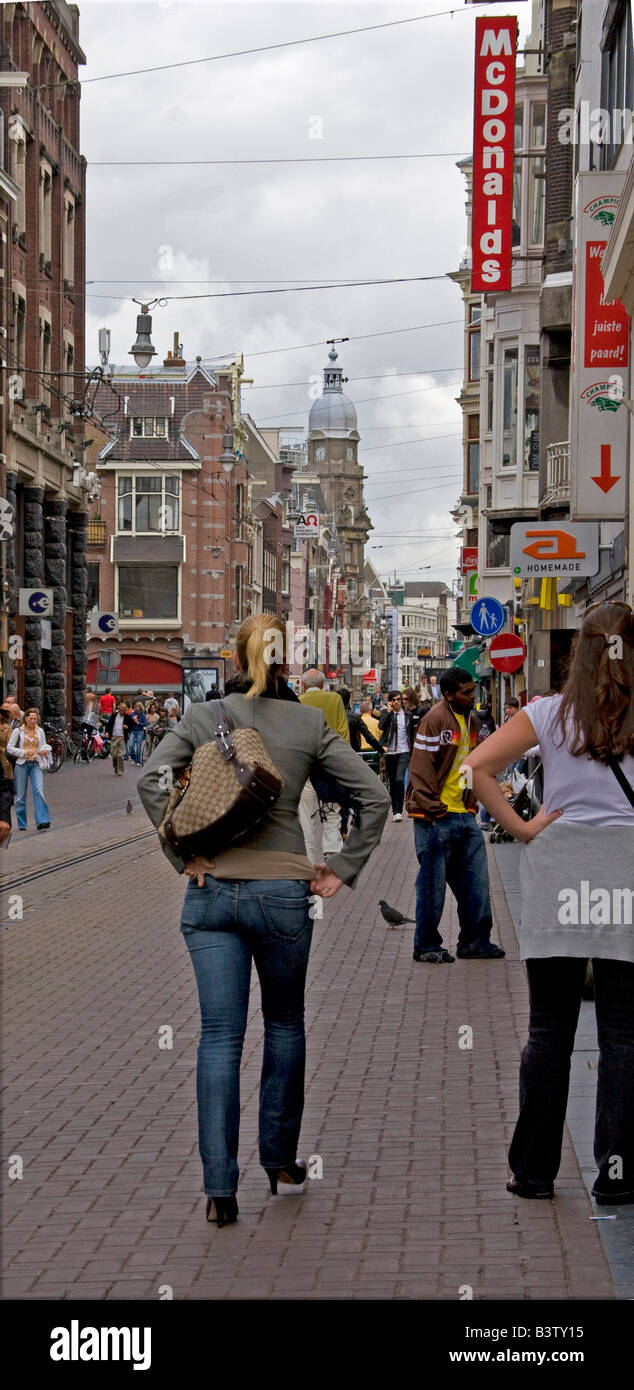 Active Amsterdam street with many people walking past stores Stock ...