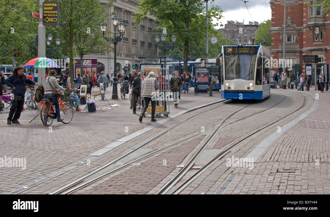 A colorful Amsterdam street scene with a tram on a track and active ...