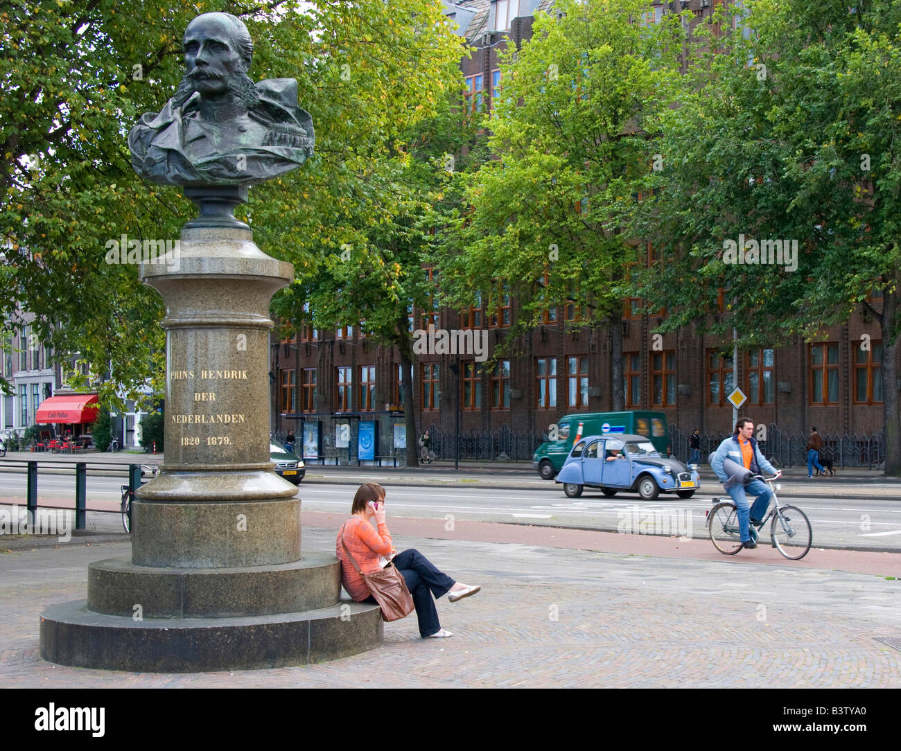 A woman talking on her cell phone beneath the Prins Hendrik bust with a ...