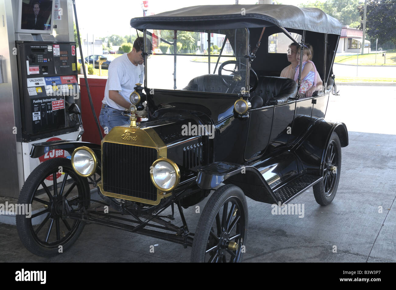 man examines his Model T Ford at a gas station in Bellville, Michigan ...
