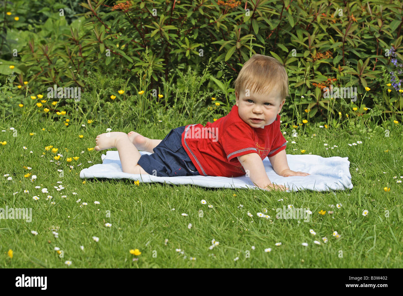 Boy lying on grass arms hi-res stock photography and images - Alamy
