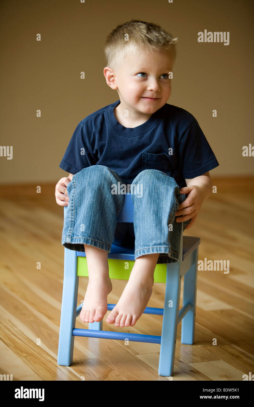 Little boy sitting on a chair Stock Photo - Alamy