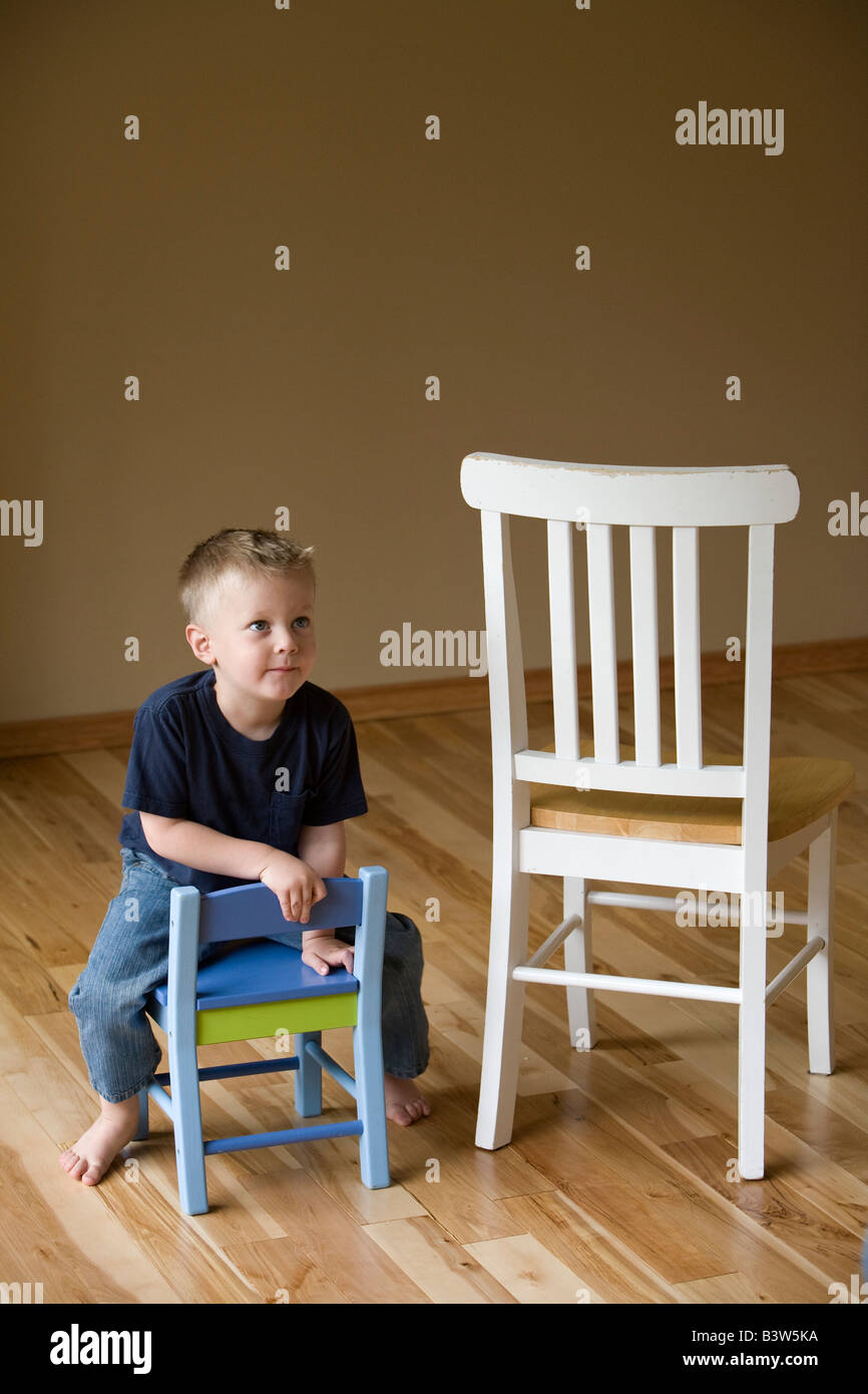 Little boy sitting on a chair Stock Photo - Alamy