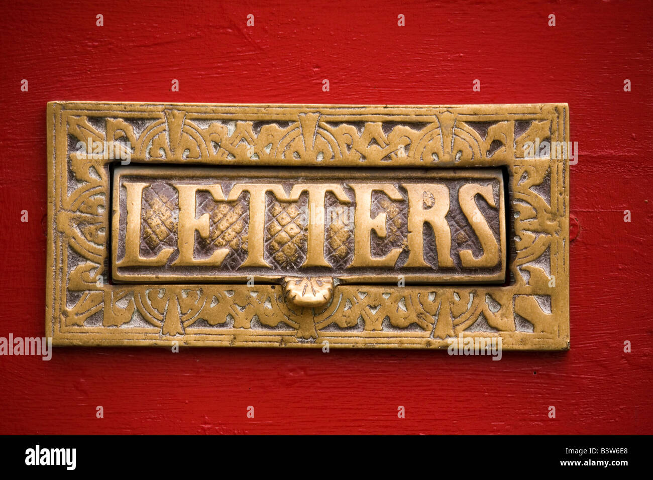 A brass letterbox on a red door Stock Photo - Alamy