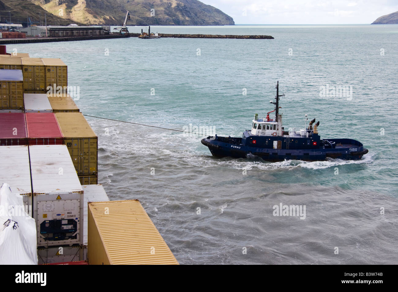 A tug pulls while assisting a ship in port, as seen from the bridge of ...