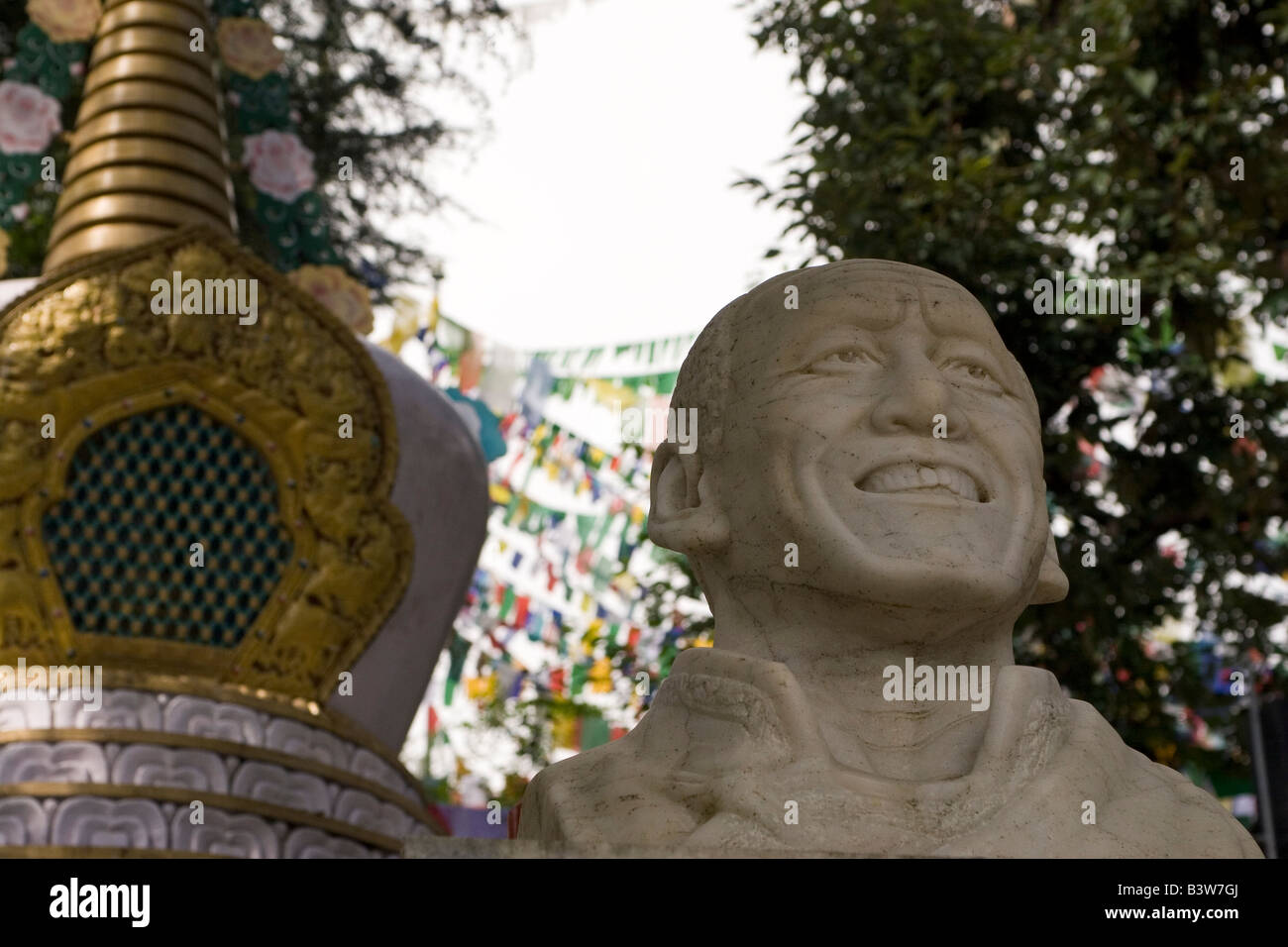 The statue of a monk in Dharamsala stands in front of a stupa Stock ...