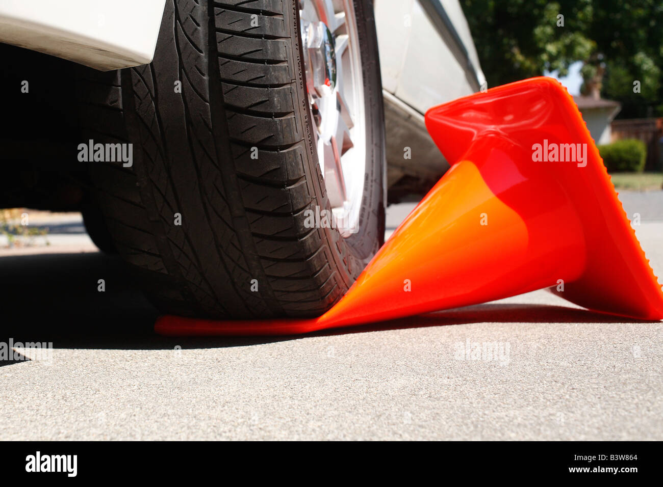 Car tire rolling over traffic cone Stock Photo - Alamy