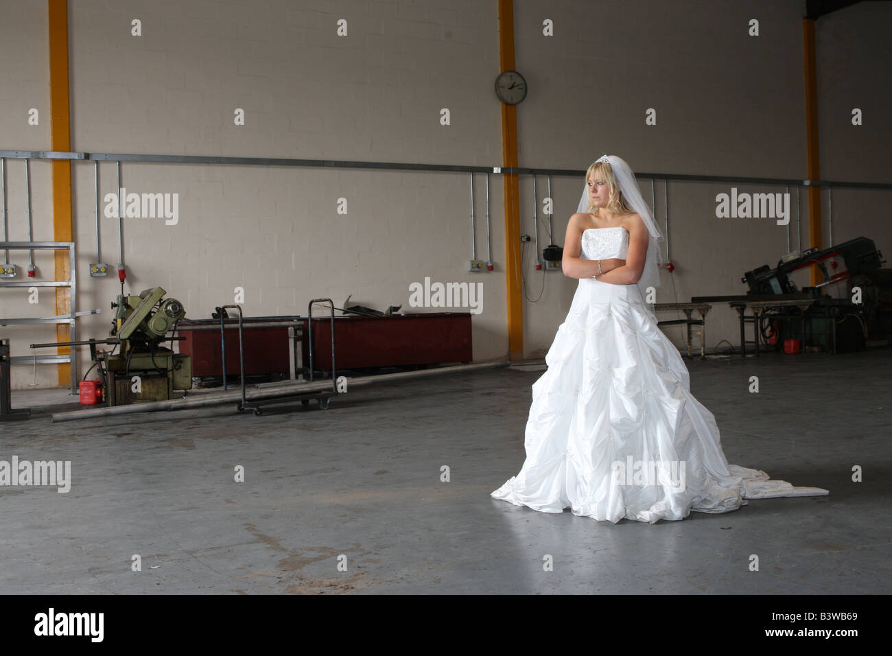 A bride standing in a workshop waiting for her bridegroom Stock Photo ...