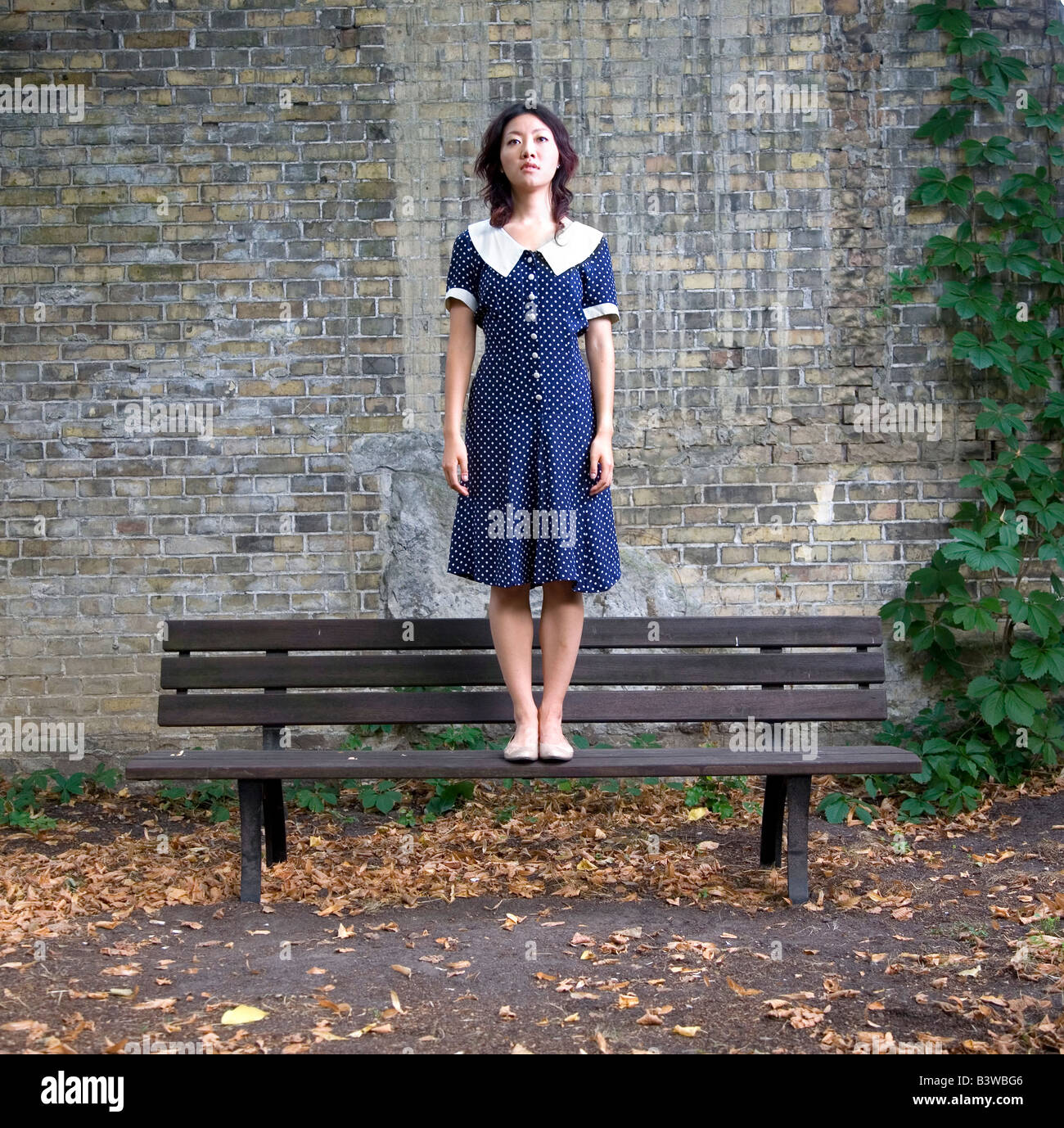 Japanese girl standing on wooden bench Stock Photo - Alamy