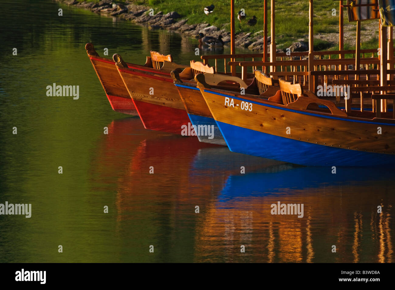 Colorful boats along shoreline of Lake Bled at sunrise, Bled, Slovenia ...