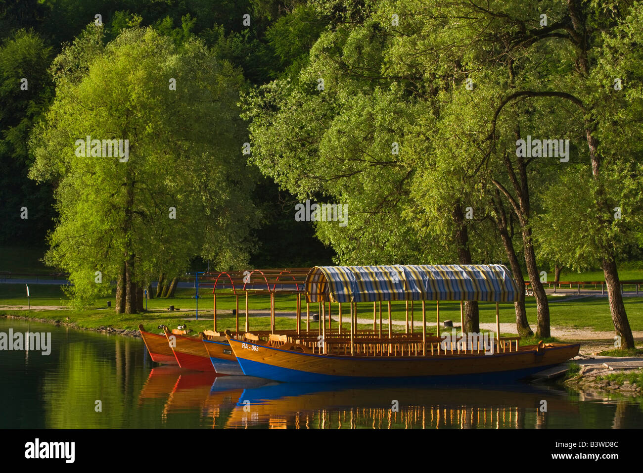 Colorful boats along shoreline of Lake Bled at sunrise, Bled, Slovenia ...