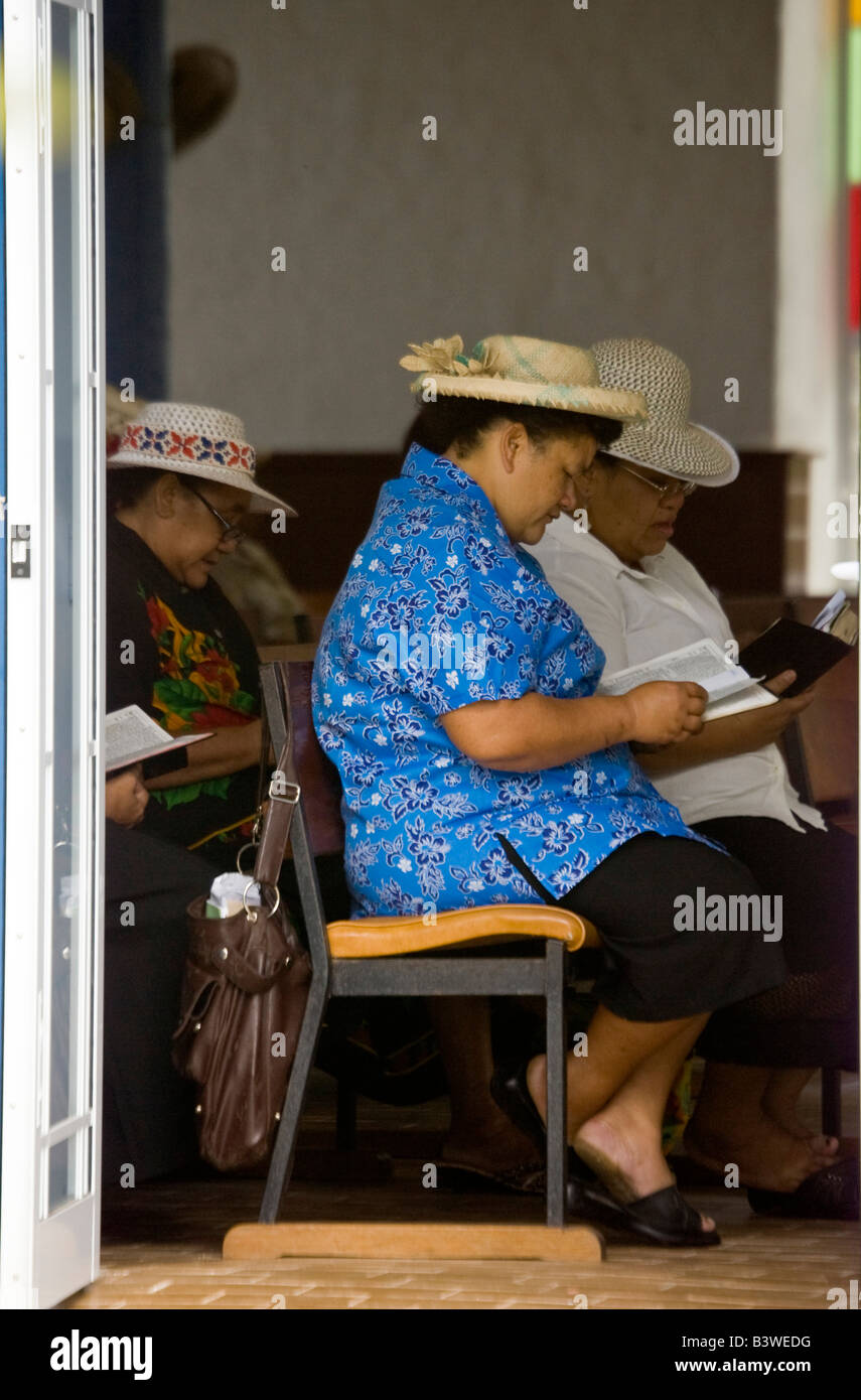 Oceania, Polynesia, Cook Islands, Rarotonga. Women reading prayer book ...