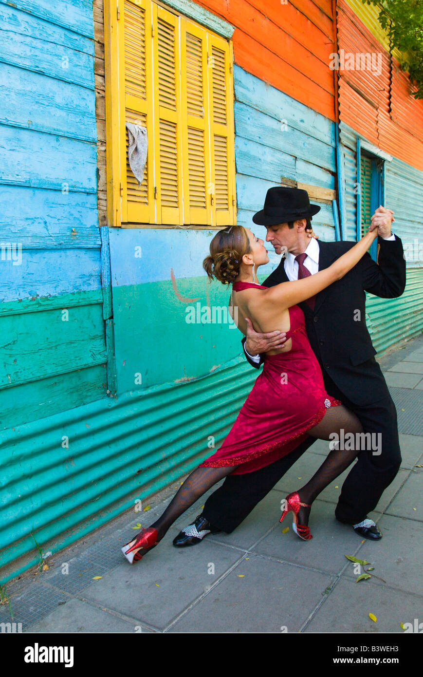 South America, Argentina, Buenos Aires, La Boca. Couple showing one of ...