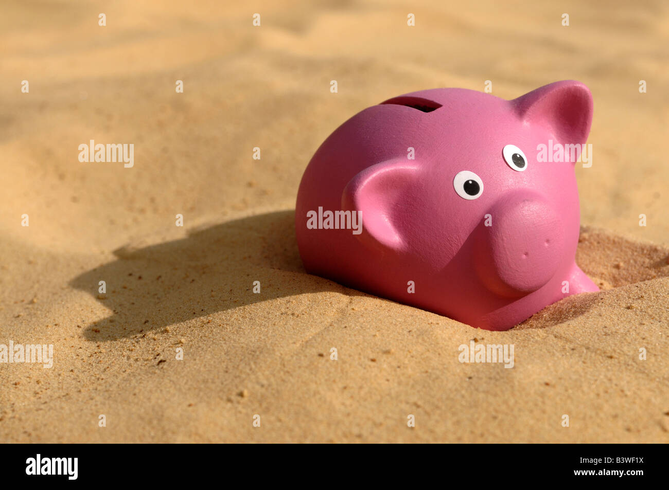 Pink piggy bank in sand Stock Photo - Alamy