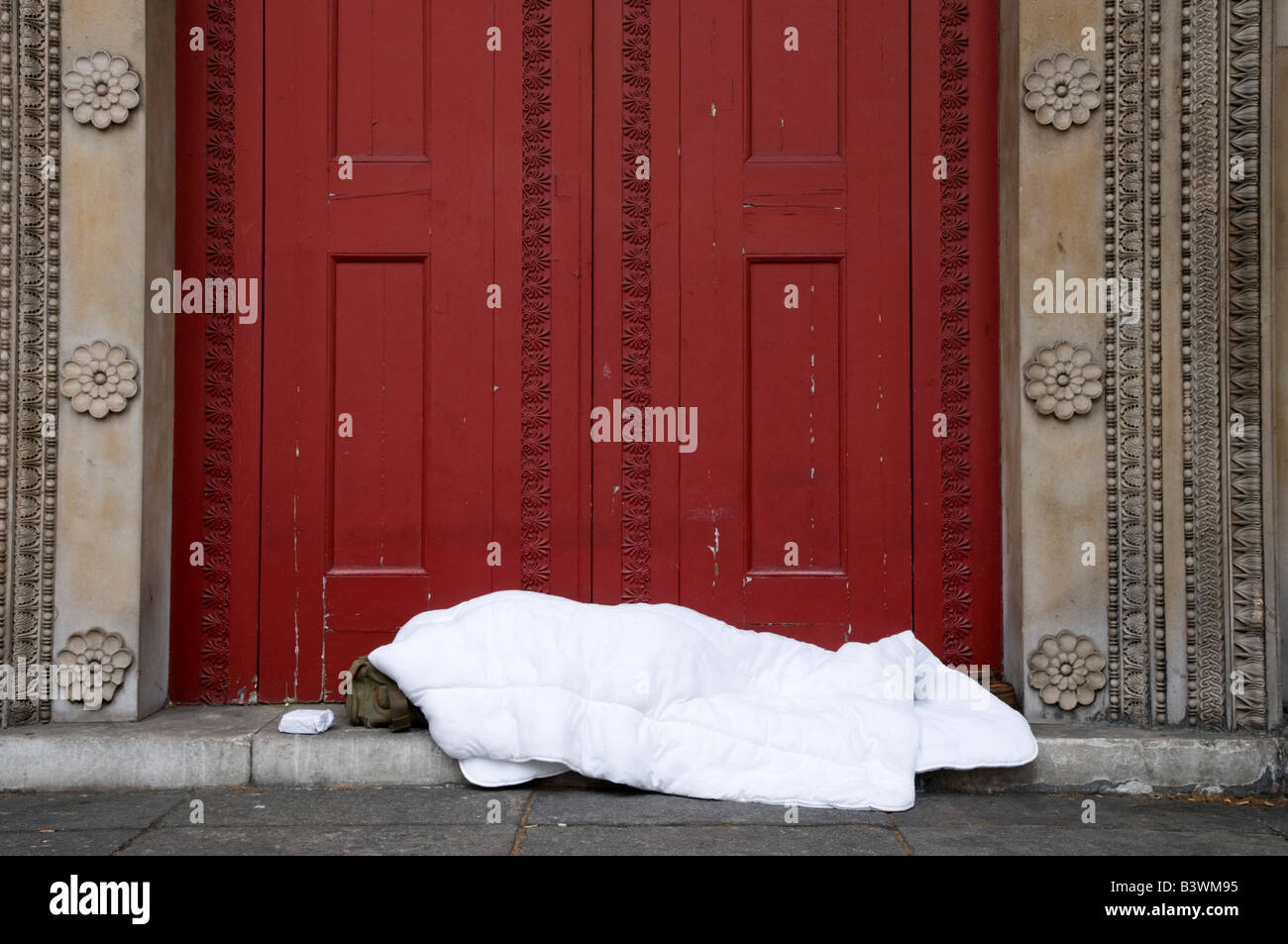 Homeless person sleeping in a doorway on the street, London, England ...