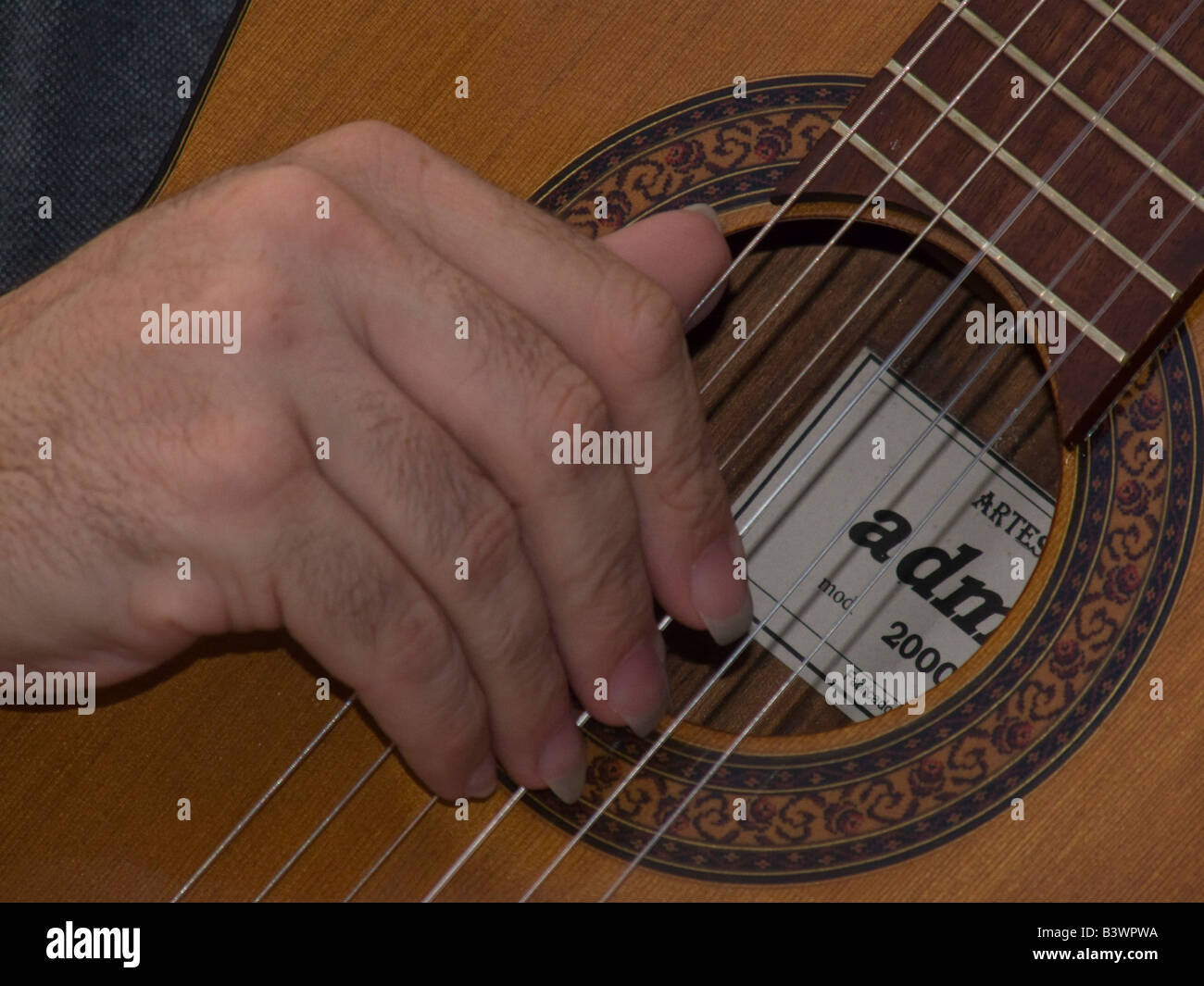 Close-up of a person's hand playing a guitar Stock Photo - Alamy