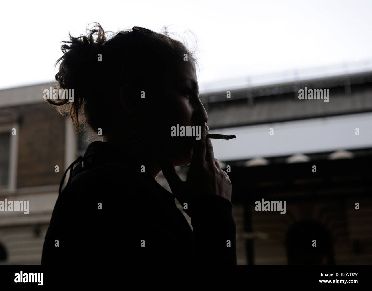 Side profile of a young woman smoking a cigarette, London, England ...