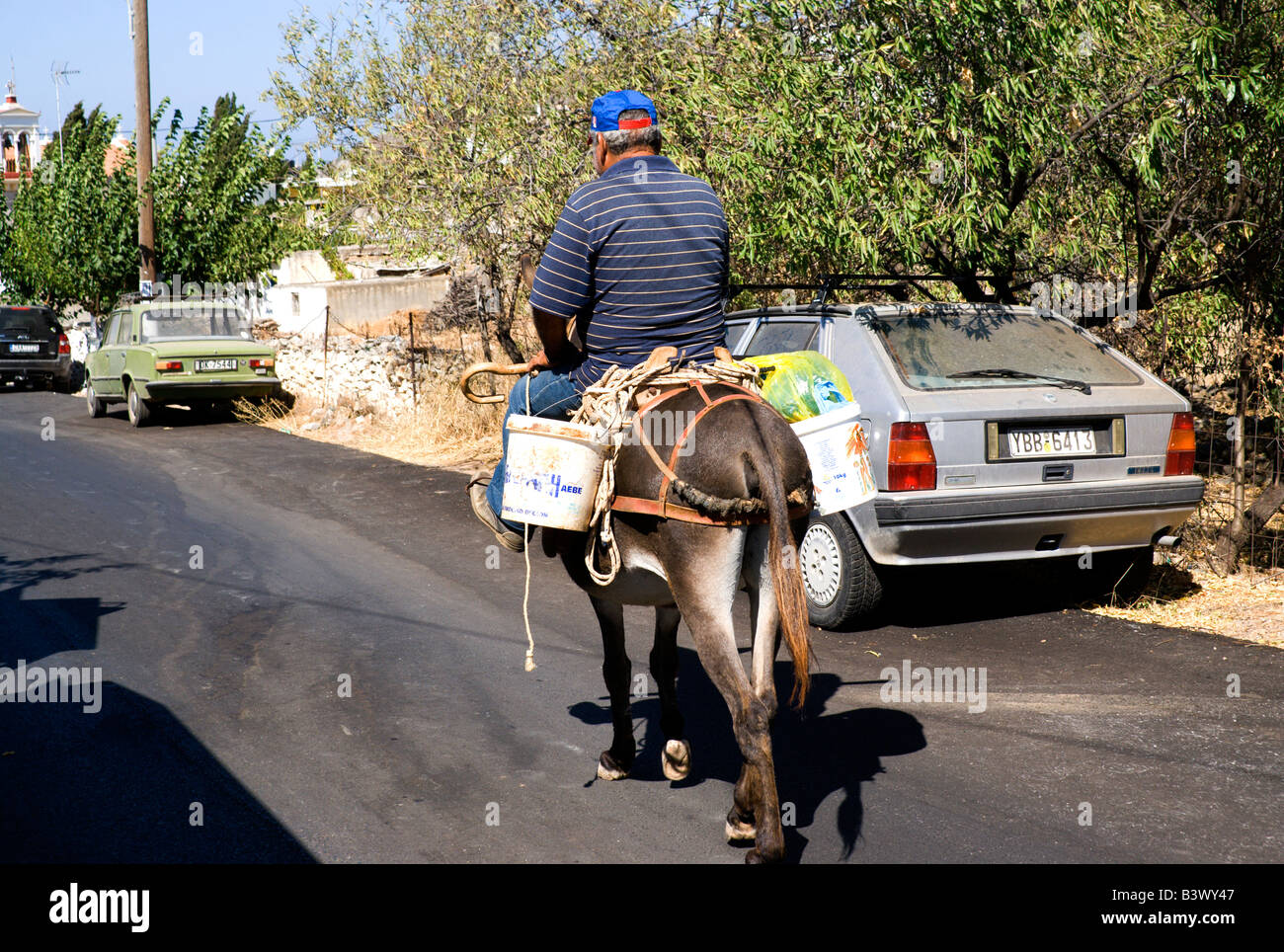 man riding donkey vrouhas near elounda crete greece Stock Photo - Alamy