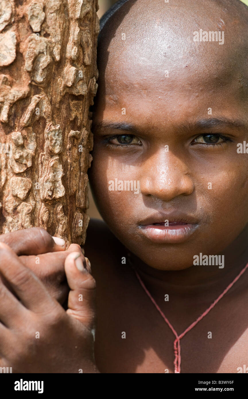 Indian boy leaning against tree Stock Photo - Alamy