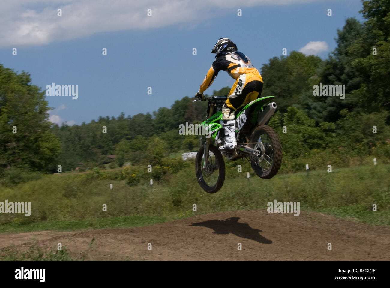 Man jumping on a motocross track with sky in the background Stock Photo ...