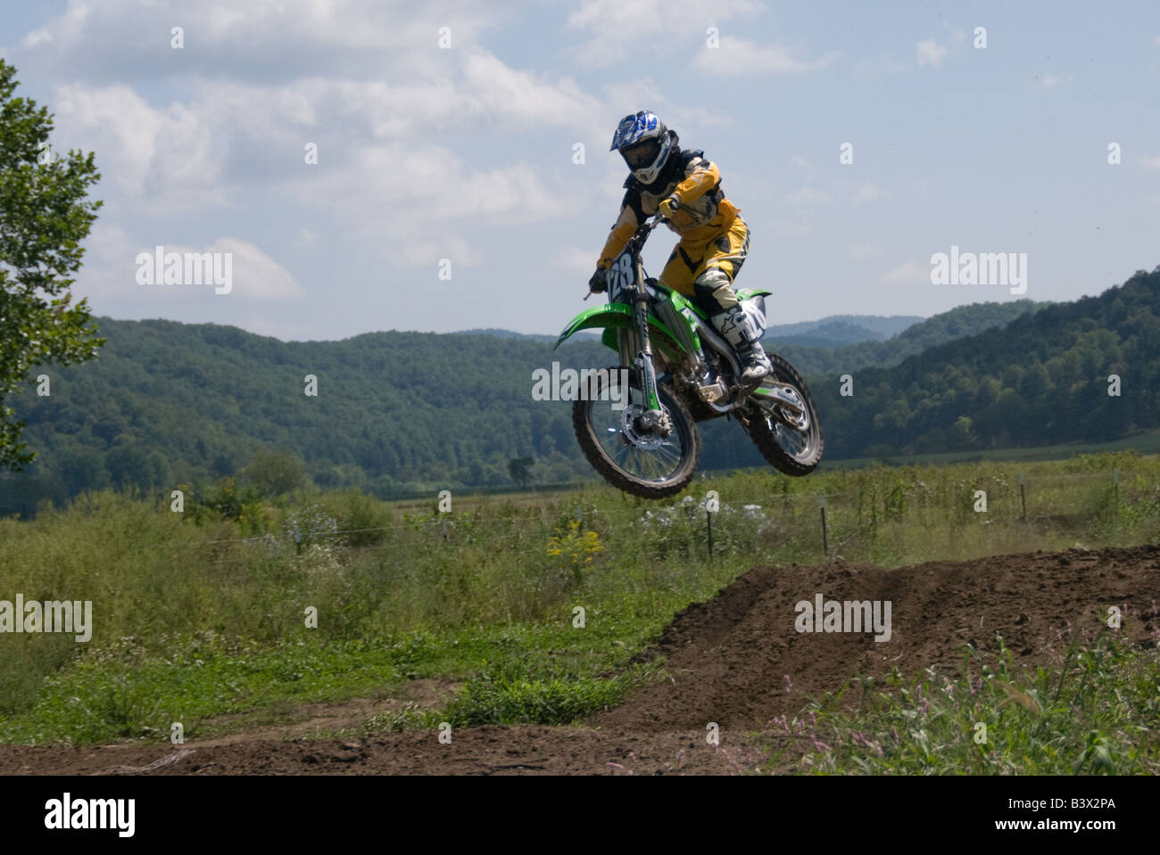 Man jumping on a motocross track with sky in the background Stock Photo ...
