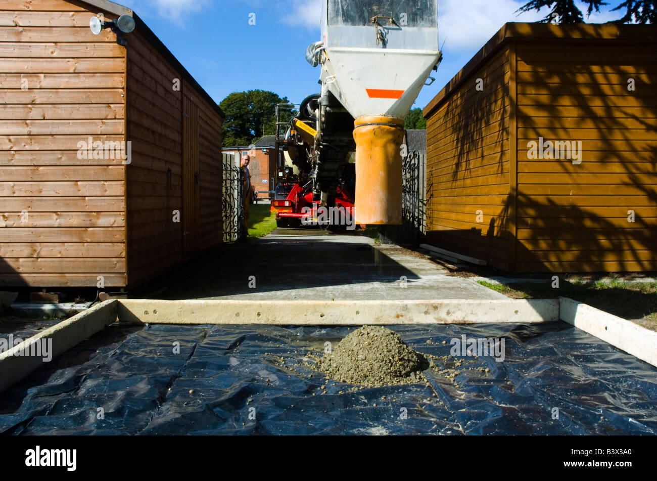 A cement concrete mixer pours concrete into the raft screed Stock Photo ...