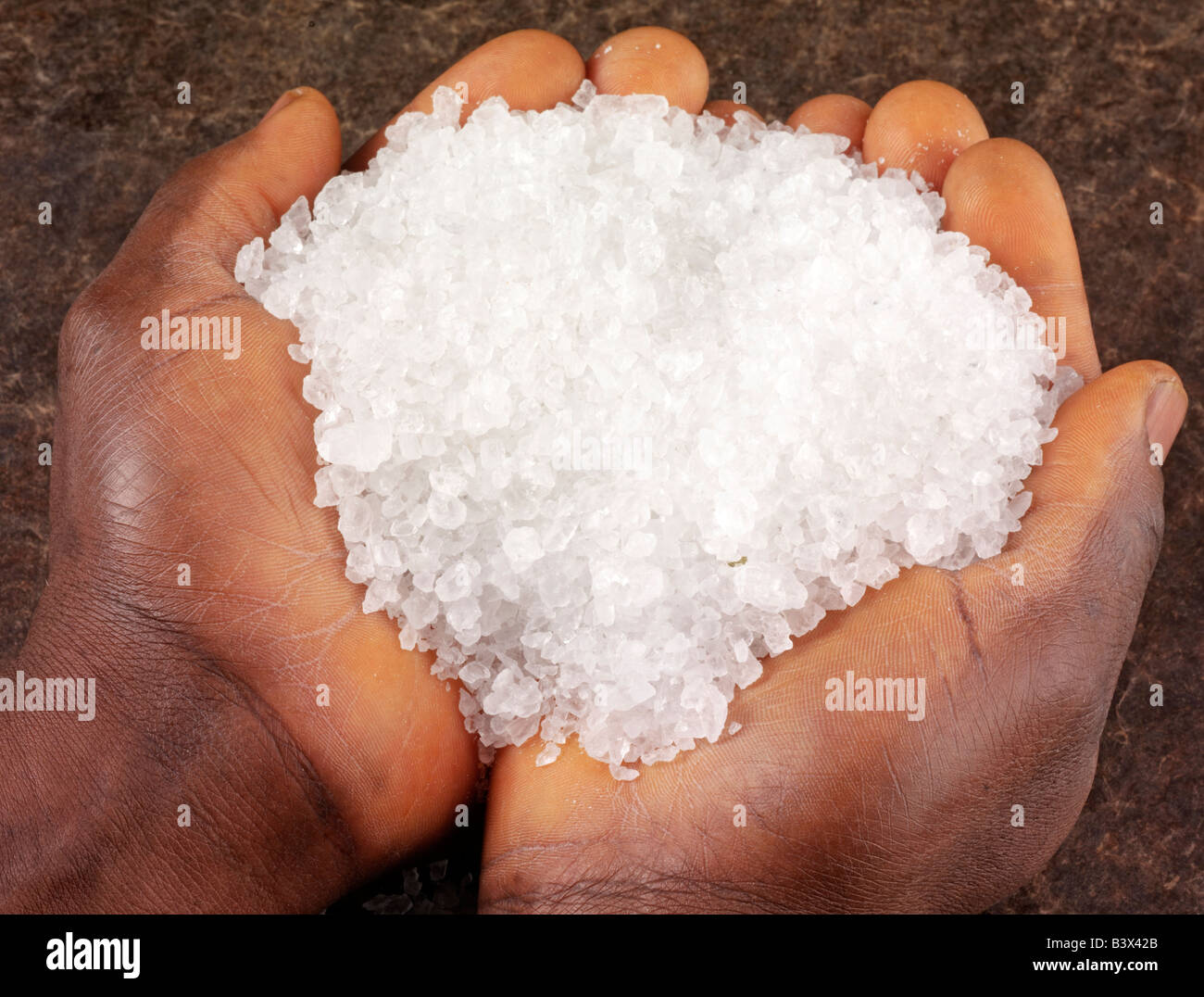 MAN HOLDING ROCK SALT GRANULES Stock Photo - Alamy