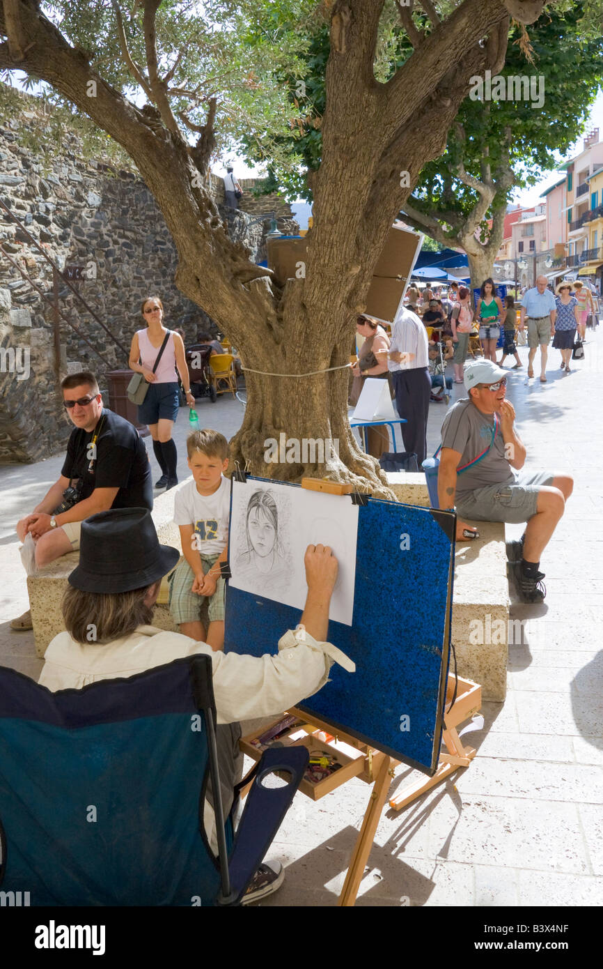 A painter sits with his easel on the roadside, drawing a portrait of a ...