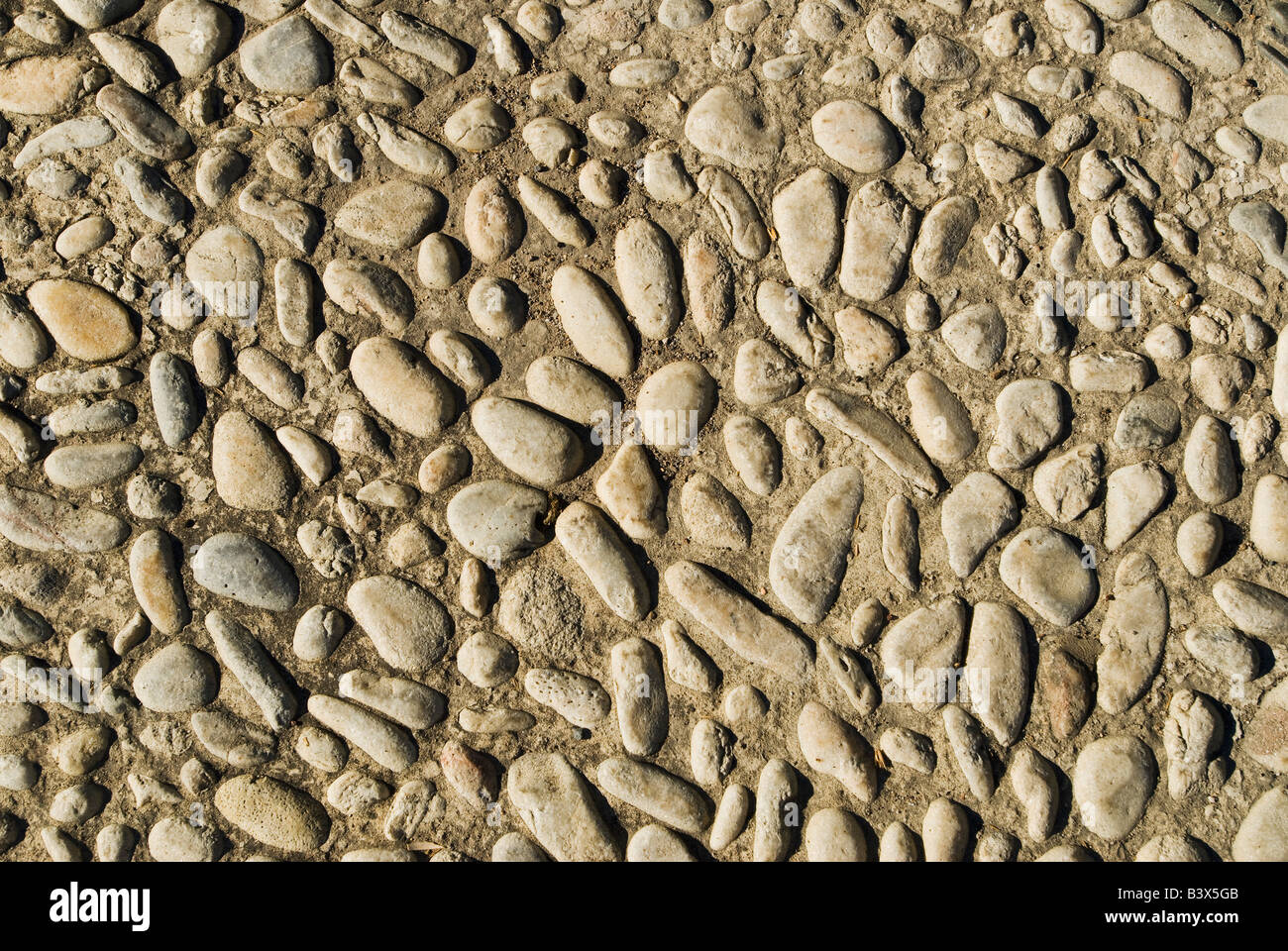 Pebbles in pavement Stock Photo - Alamy