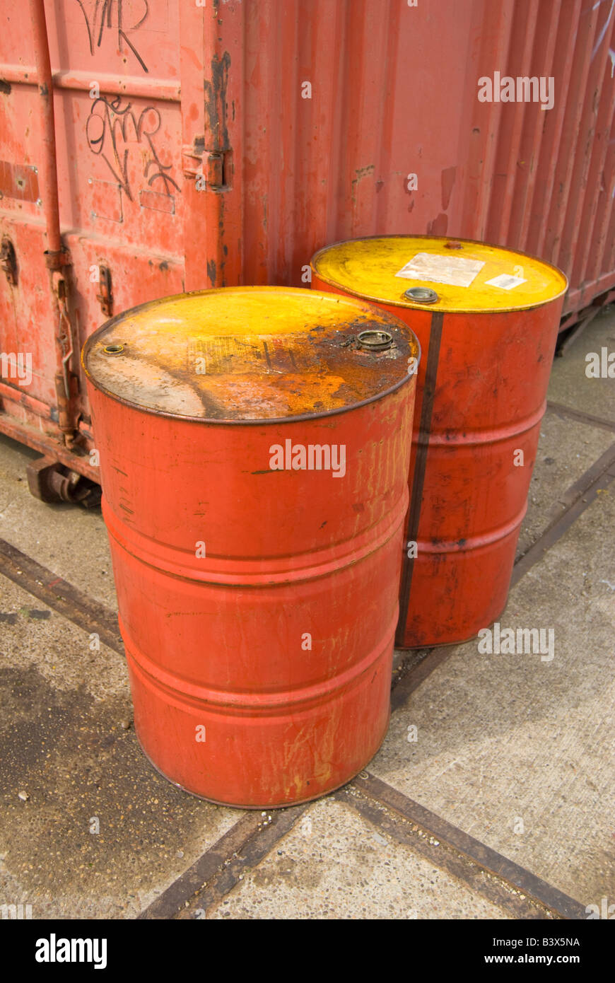 Two red oil barrels next to a shipping container Stock Photo - Alamy