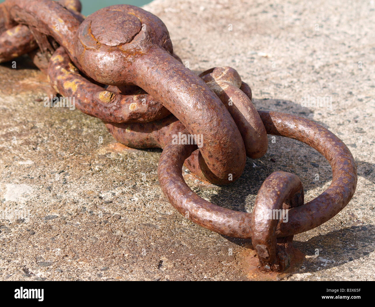 Large iron ring and chain on a harbour wall Stock Photo - Alamy