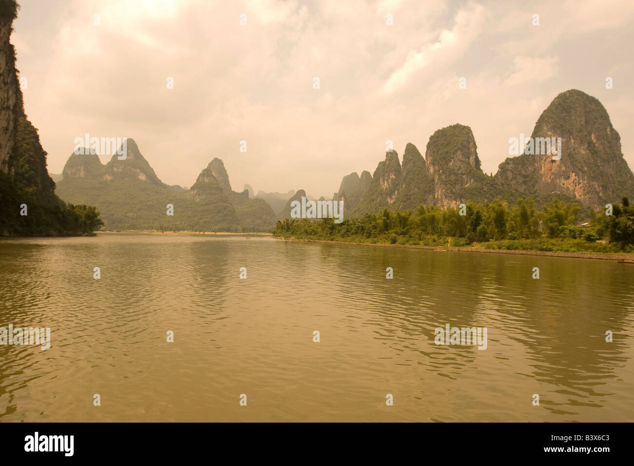 Li River snakes among limestone hills and bamboo forests between Guilin ...