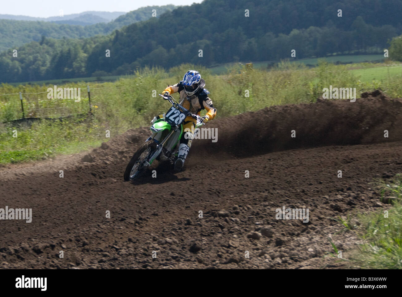 Man jumping on a motocross track with sky in the background Stock Photo ...