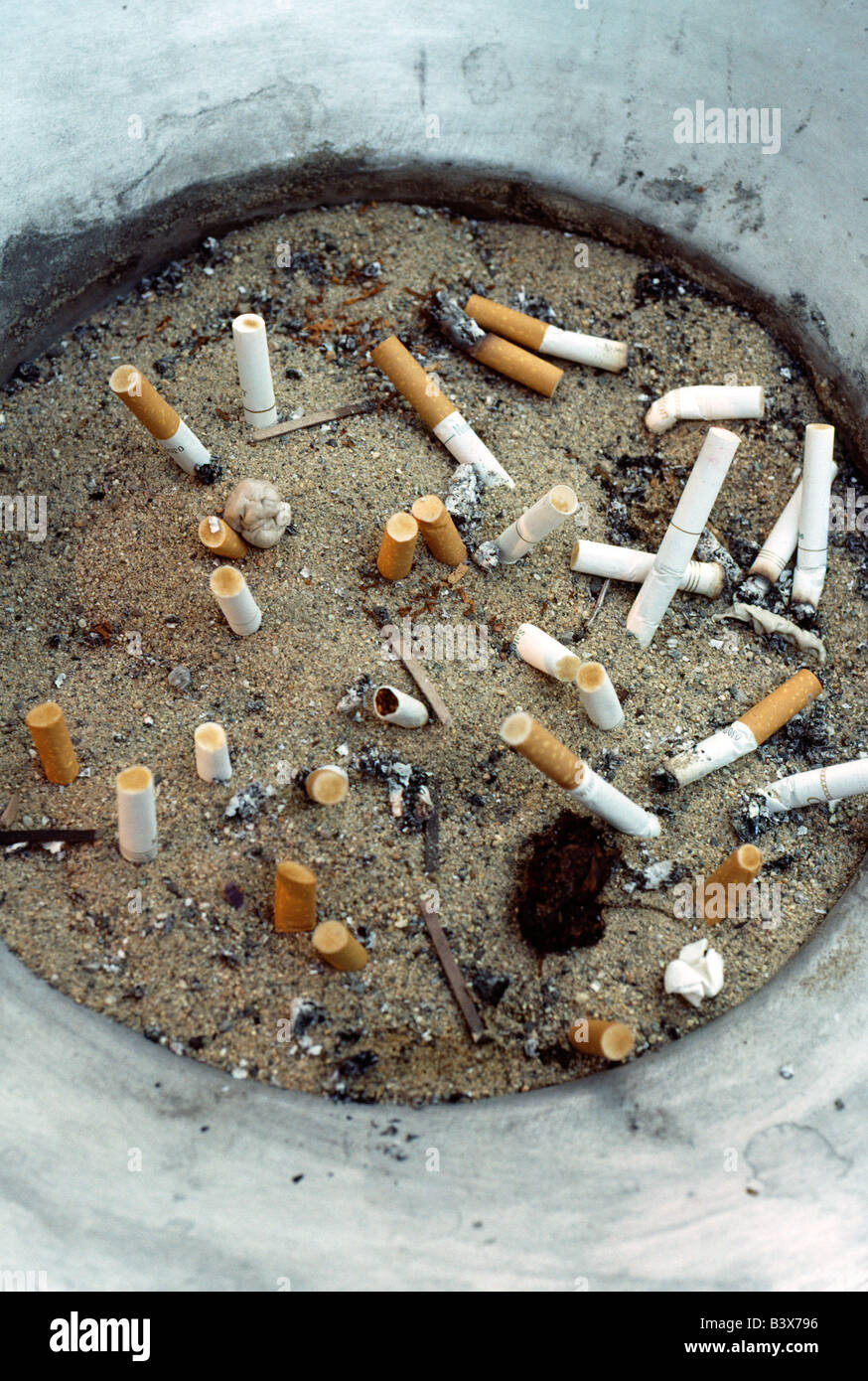 Used cigarette butts in a sand ash tray Stock Photo - Alamy