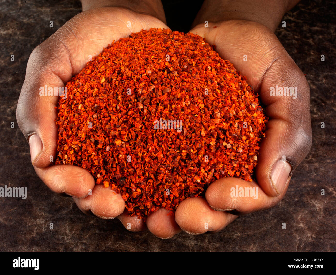 MAN'S HANDS HOLDING DRIED CHILLI FLAKES Stock Photo - Alamy