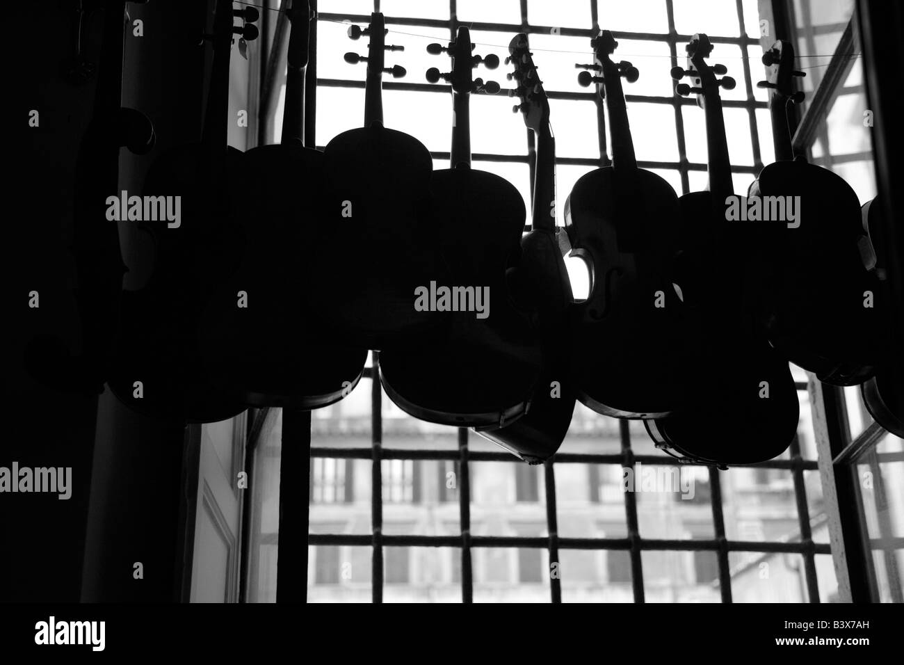 violins hanging on string in window Stock Photo - Alamy