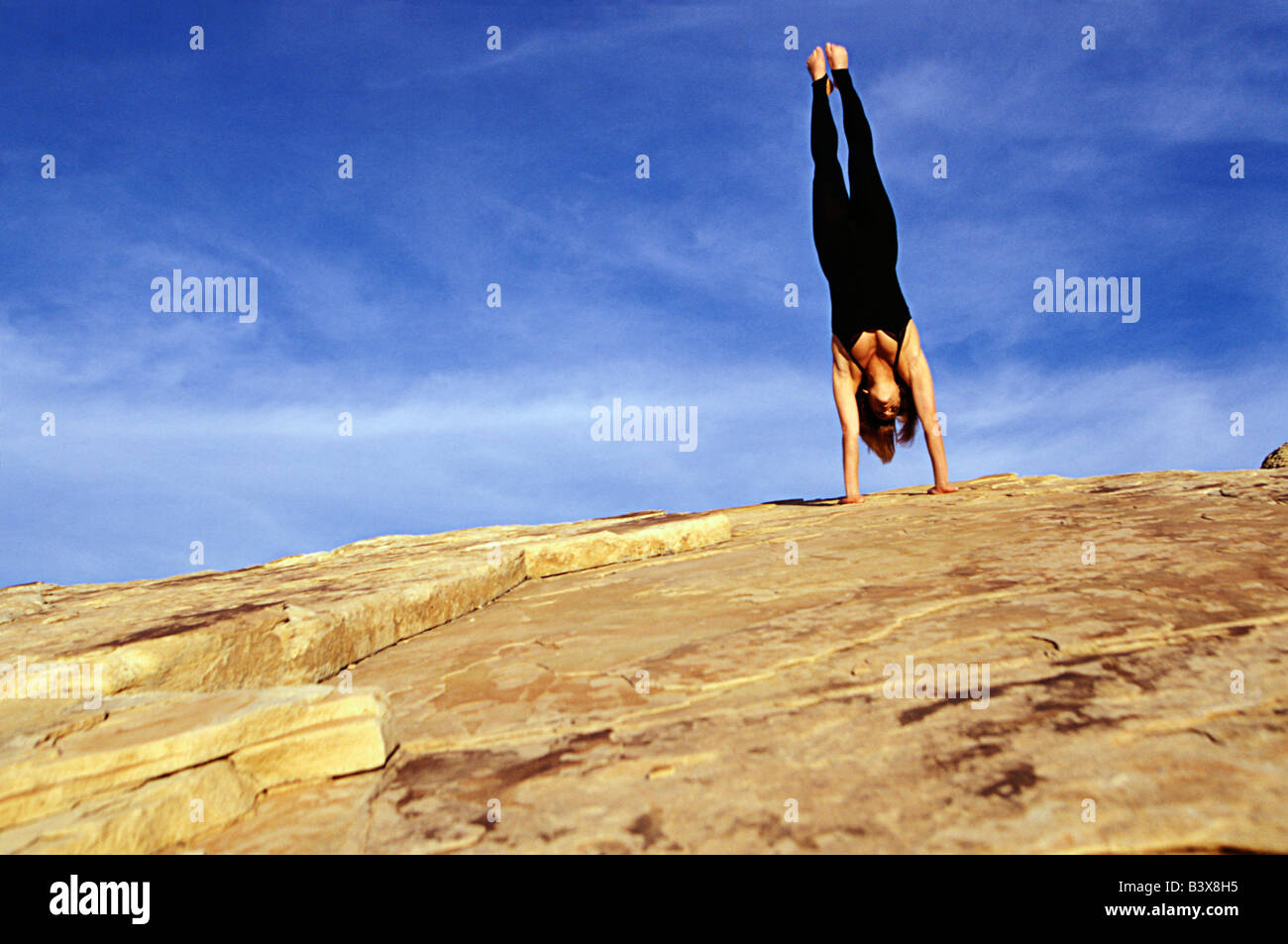 Female athlete handstand on rocky outcropping Red Rock Canyon NV USA ...