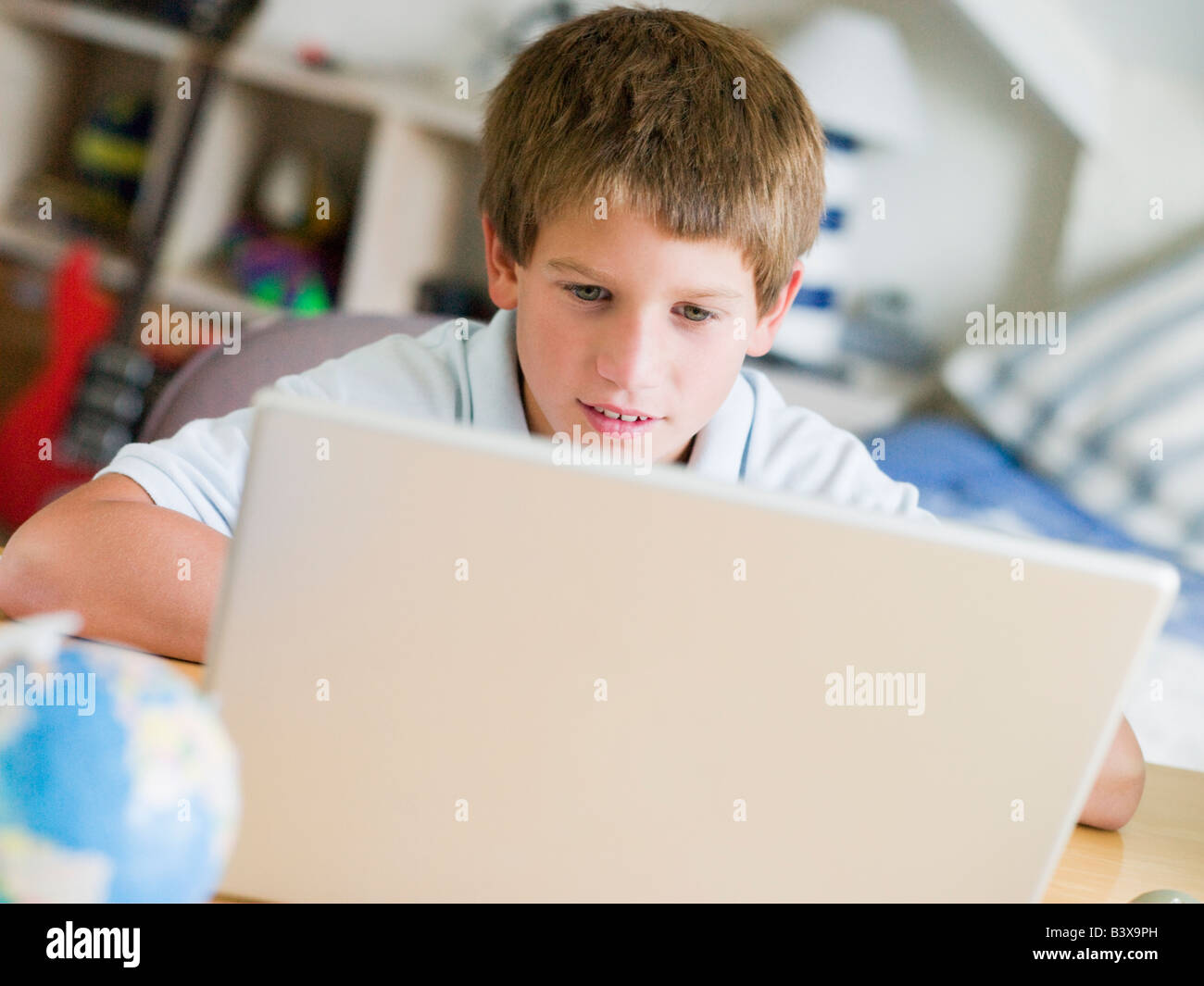 Young Boy Using Laptop In His Bedroom Stock Photo - Alamy