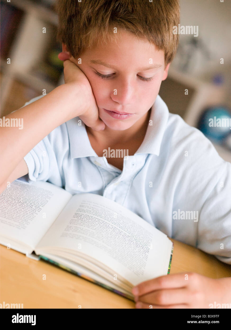 Young Boy Reading A Book In His Room Stock Photo - Alamy