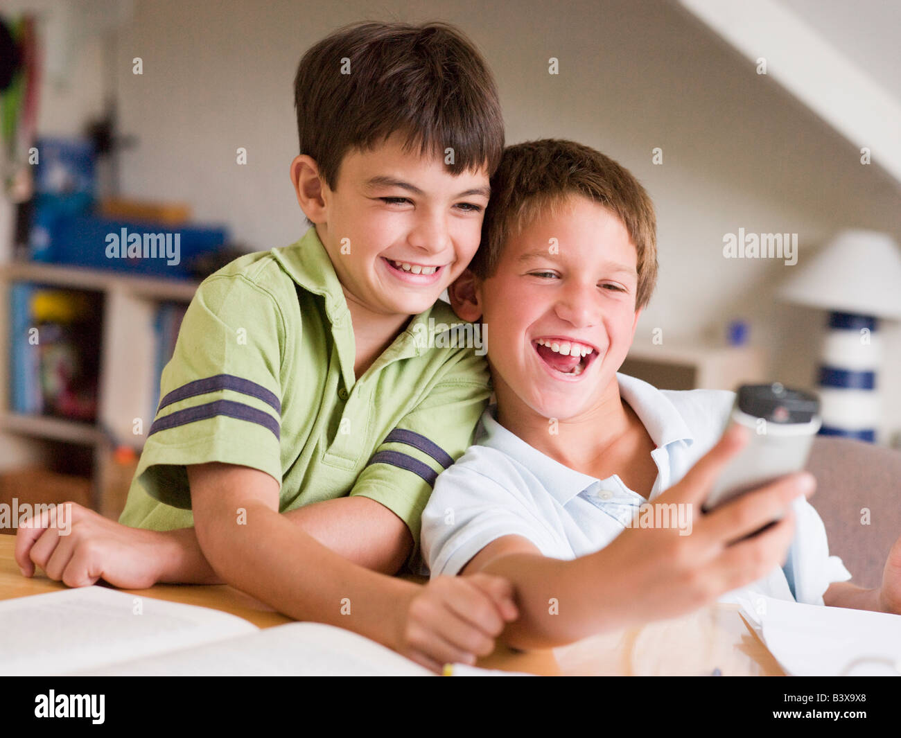 Two Young Boys Distracted From Their Homework, Playing With A Cellphone ...