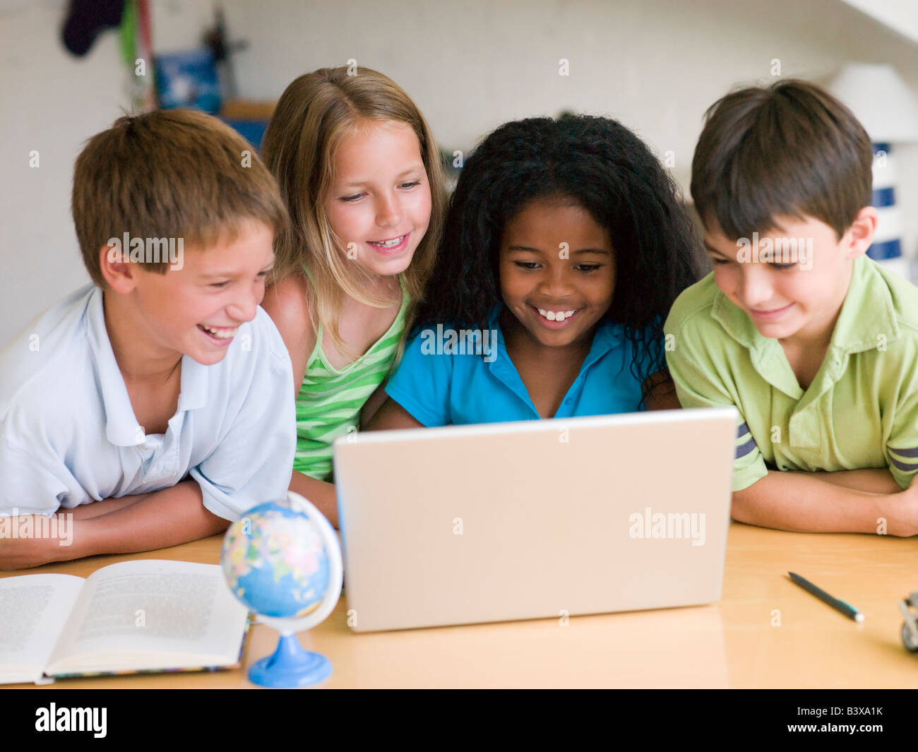Group Of Young Children Doing Their Homework On A Laptop Stock Photo ...