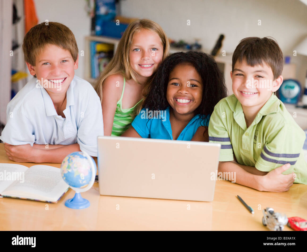 Group Of Young Children Doing Their Homework On A Laptop Stock Photo ...