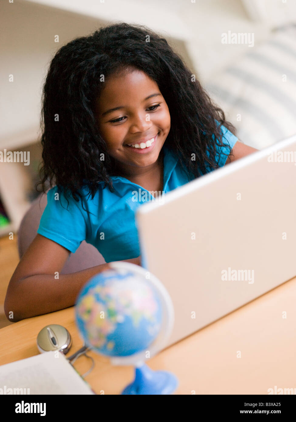 Young Girl Doing Her Homework On A Laptop Stock Photo - Alamy