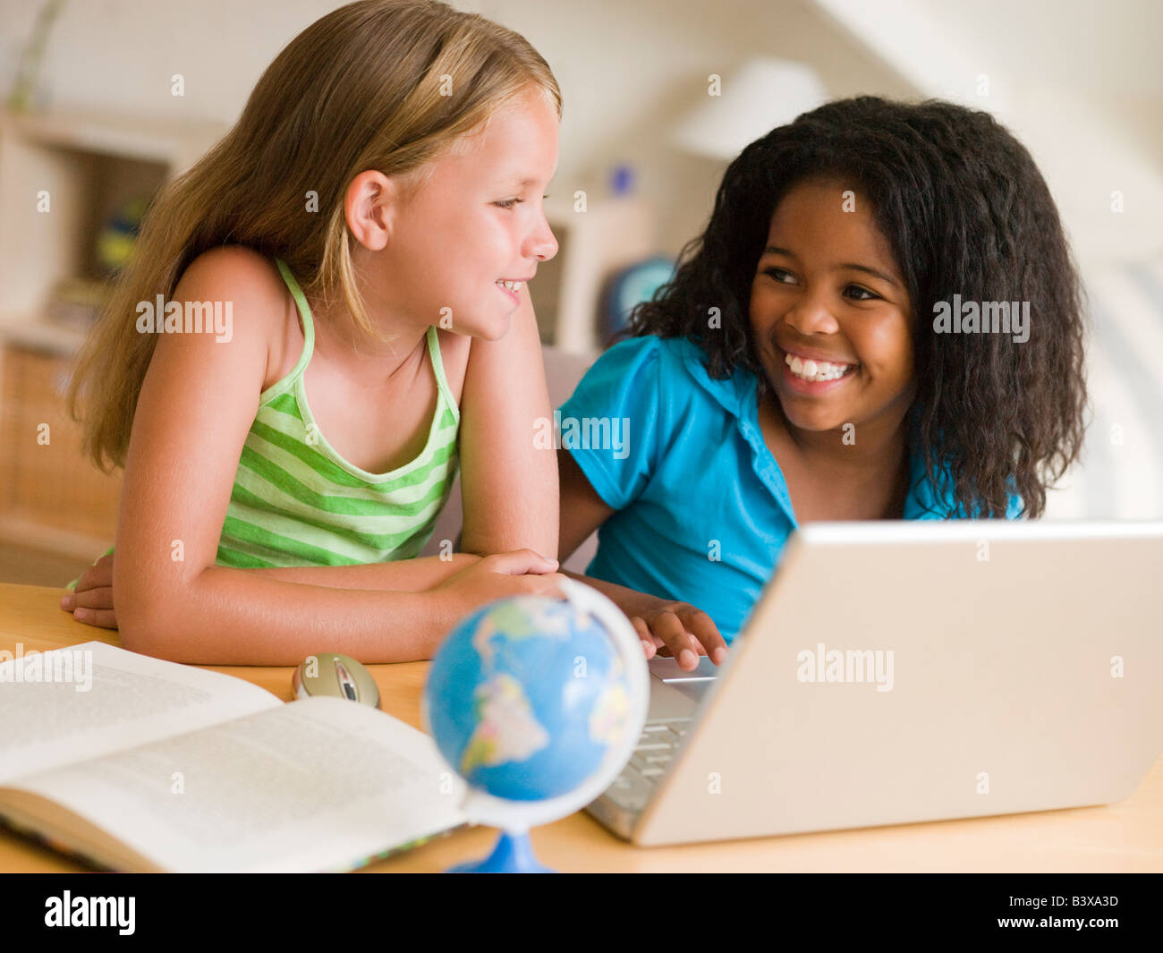 Two Young Girls Doing Their Homework On A Laptop Stock Photo - Alamy