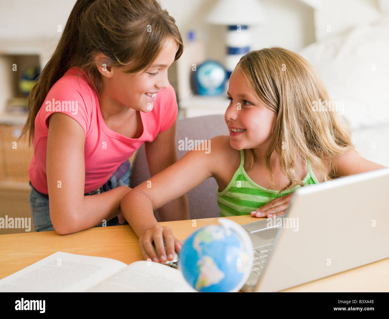 Two Young Girls Doing Homework On A Laptop Stock Photo - Alamy