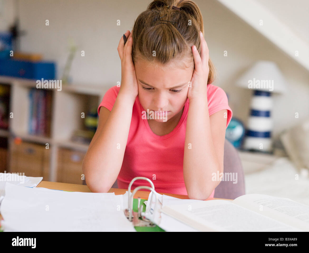 Young Girl Doing Her Homework With Her Head In Her Hands Stock Photo ...