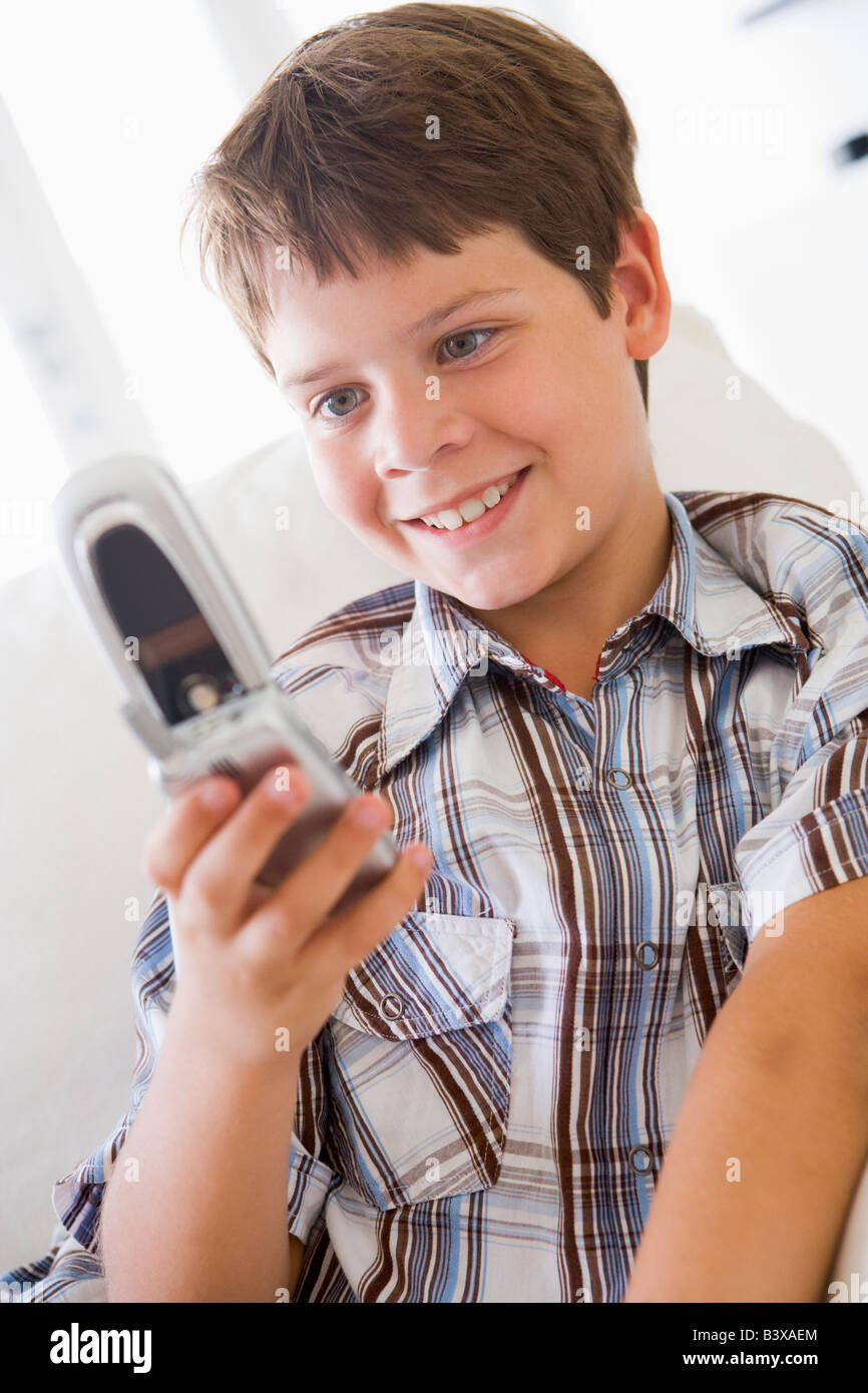 Young Boy Sitting On A Sofa Texting On A Mobile Phone Stock Photo - Alamy