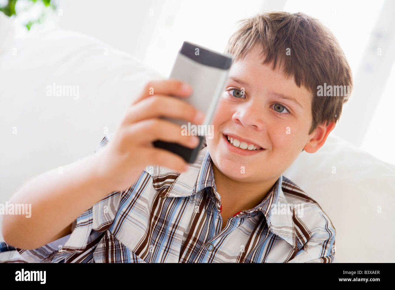 Young Boy Sitting On A Sofa Texting On A Mobile Phone Stock Photo - Alamy