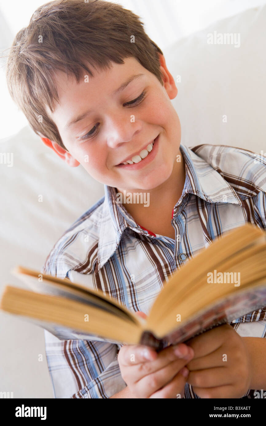 Teen boy reading book on sofa hi-res stock photography and images - Alamy