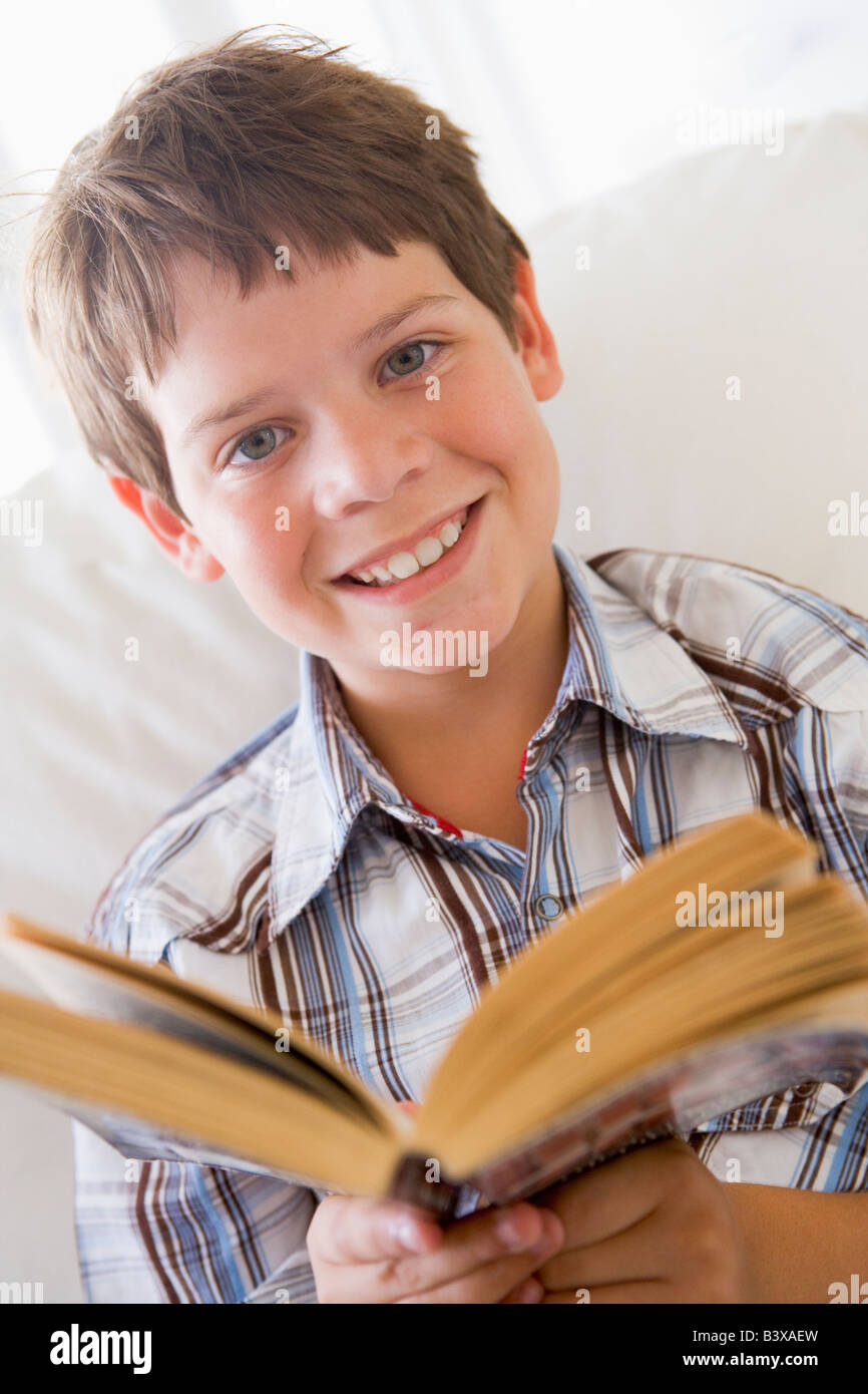 Teen boy reading book on sofa hi-res stock photography and images - Alamy